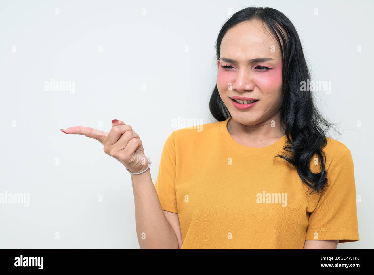Studio portrait of a young Thai transgender individual with makeup and ...