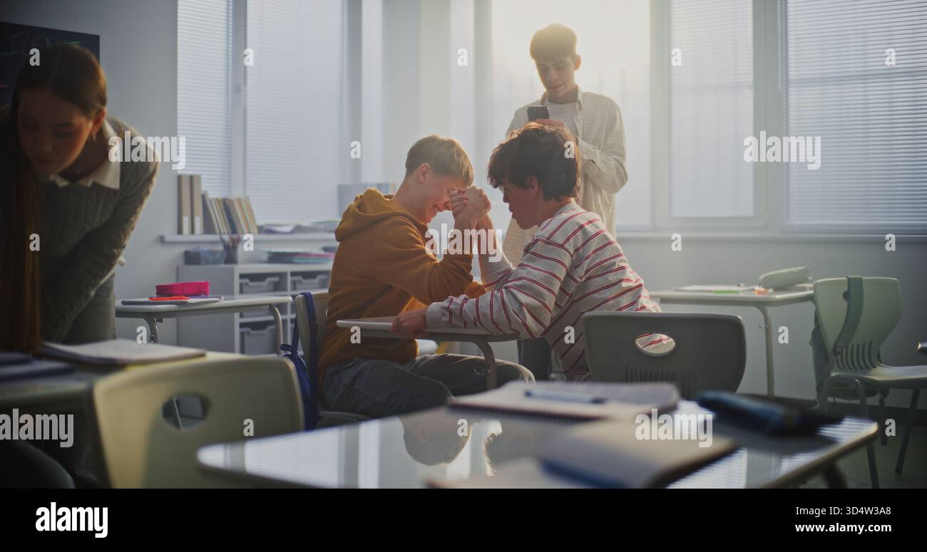 Students playfully arm wrestle desk hi-res stock photography and images ...