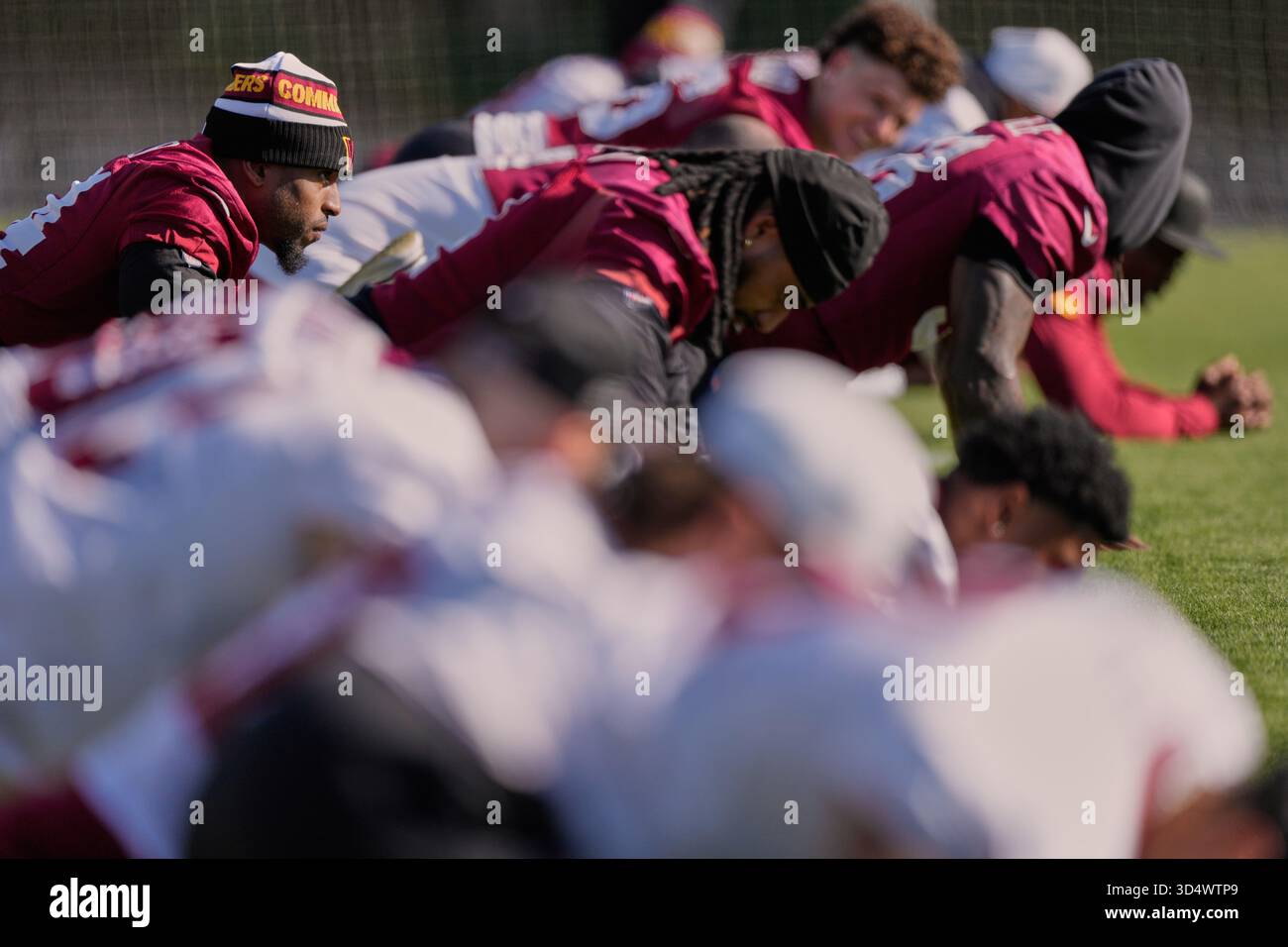 Washington Commanders players warm up during a training session in ...