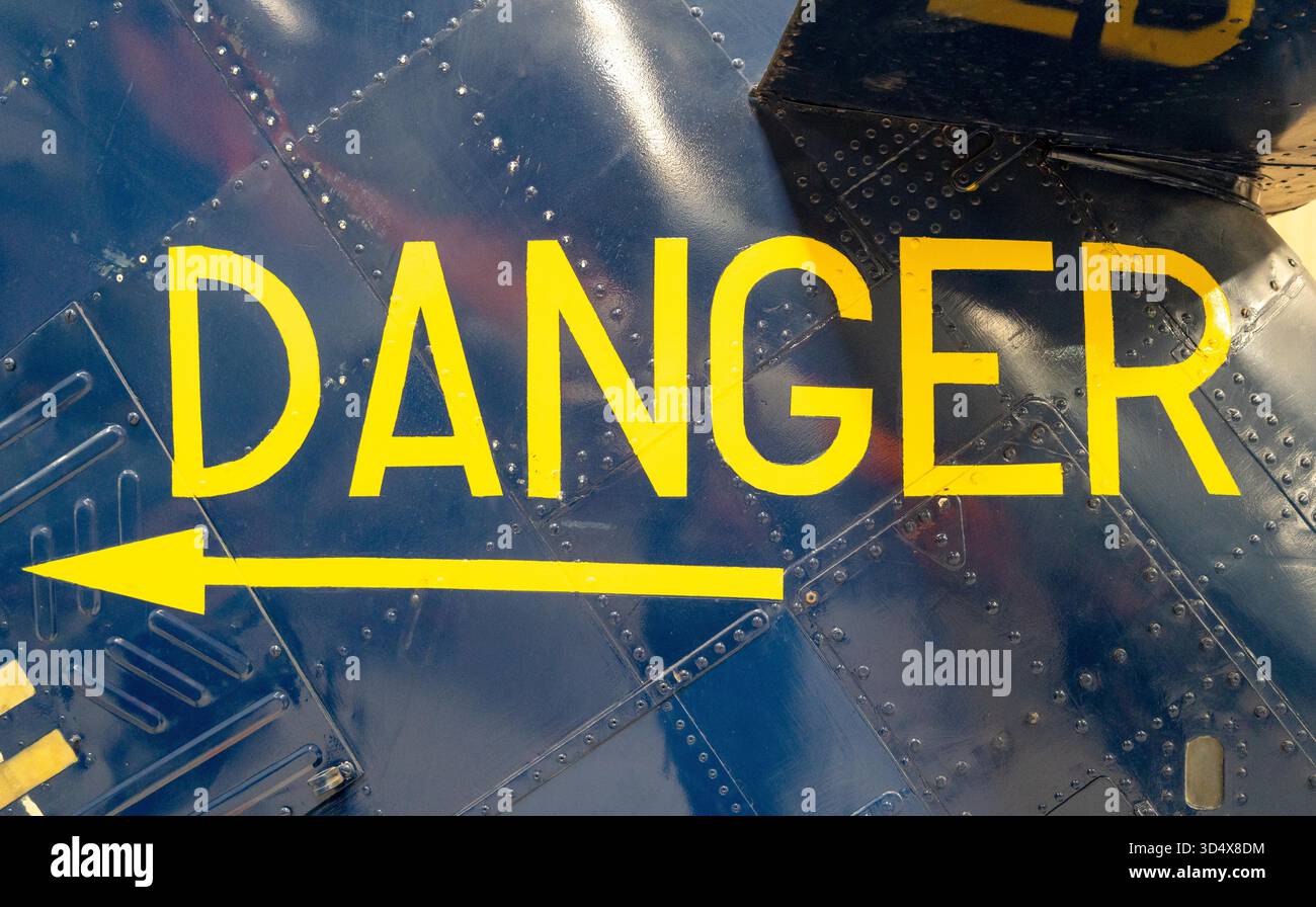 Close-up of a vintage aircraft fuselage featuring a bold yellow -Danger ...