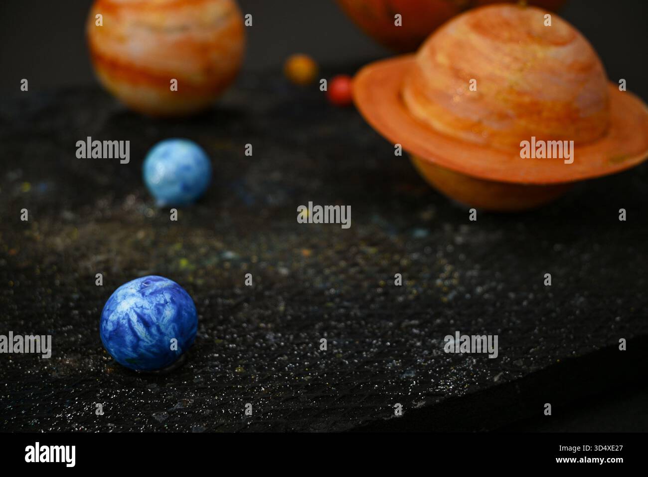 Handcrafted models of planets representing the solar system on a dark ...