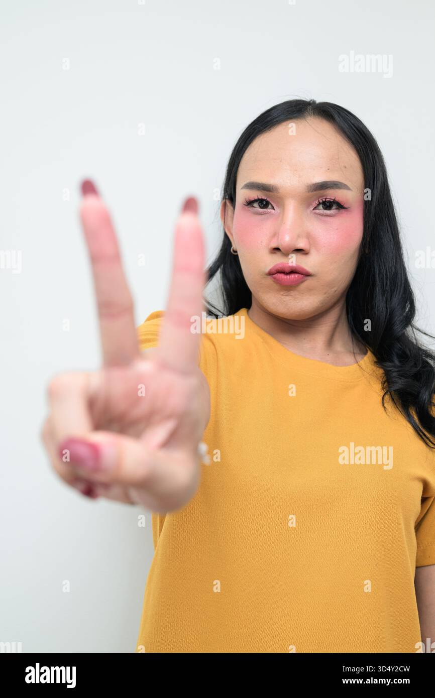 Studio portrait of a young Thai transgender individual with makeup and ...