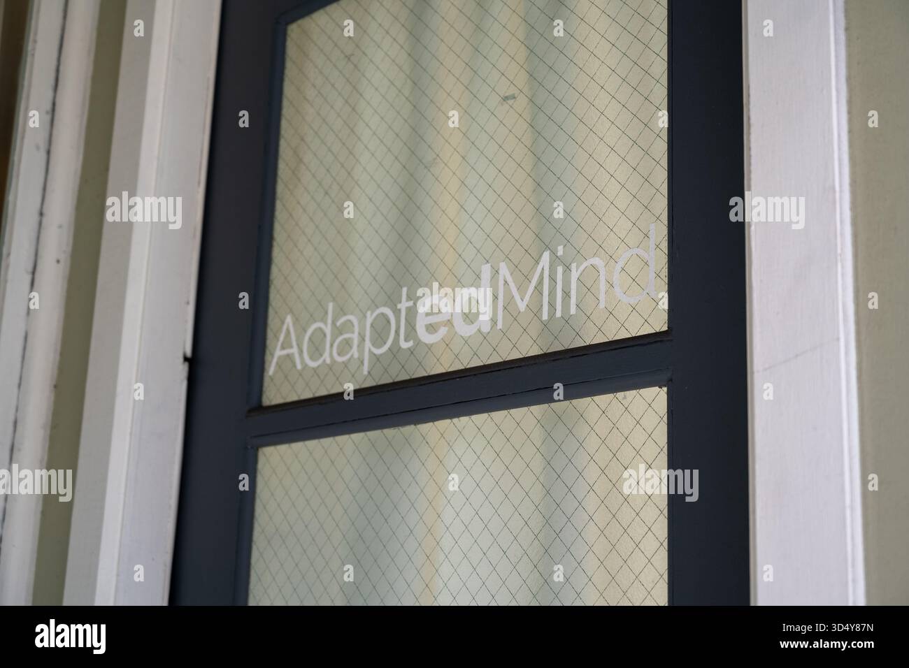 Door with education technology AdaptedMind logo on wired glass office ...