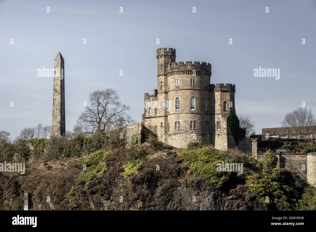 View of a historic castle and a tall monument rise from the rugged ...