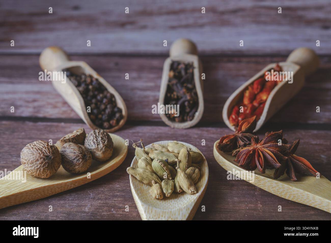 Various whole spices and dried chili peppers are artfully arranged on ...