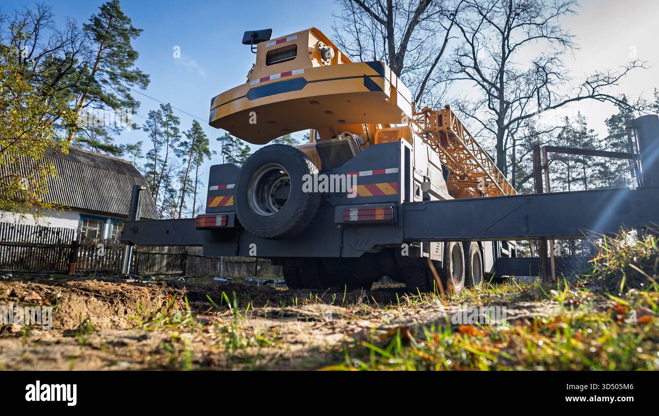 The truck crane prepares to move the load by extending the hydraulic ...