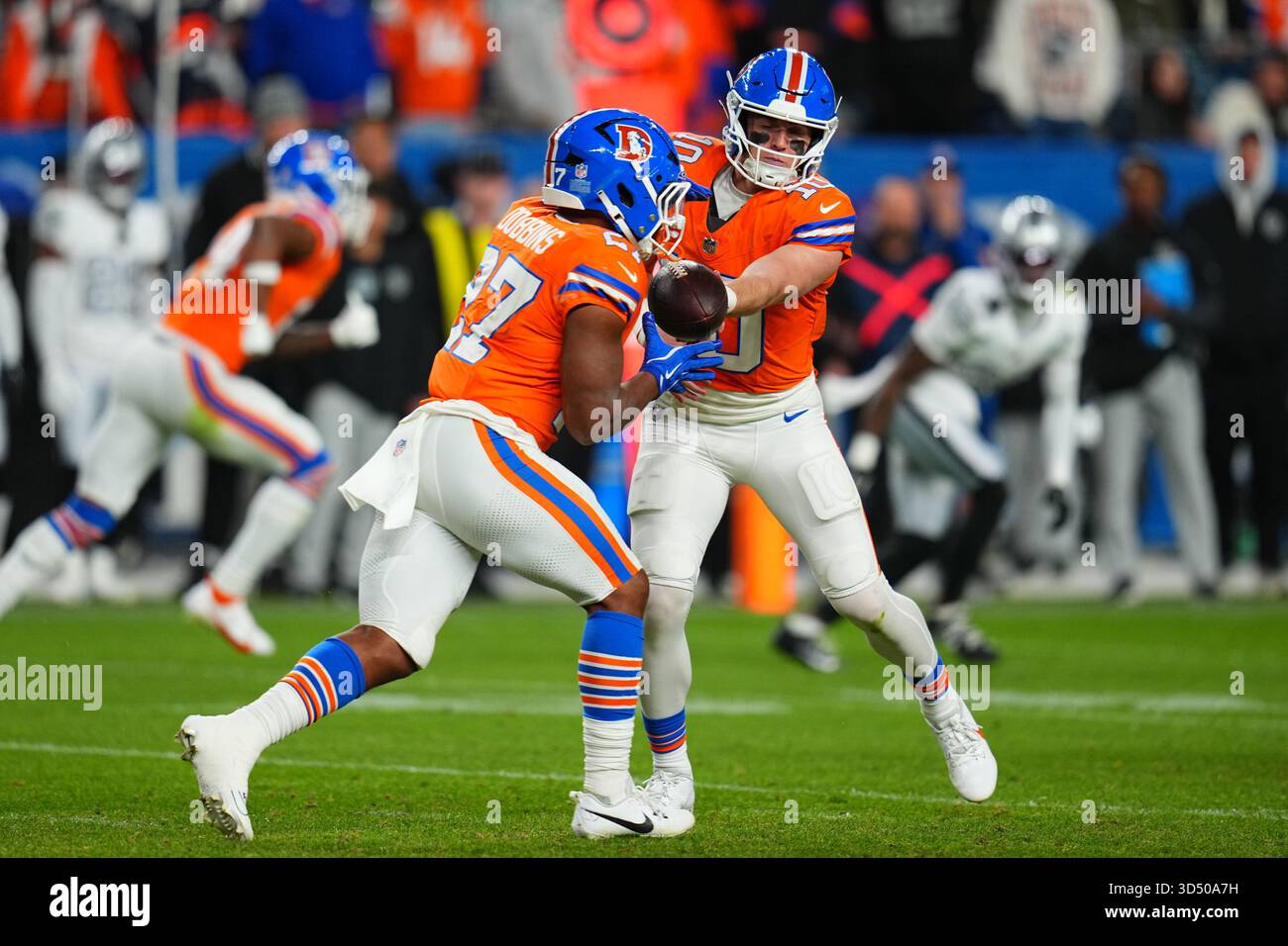 Denver Broncos quarterback Bo Nix (10) hands off to running back J.K ...