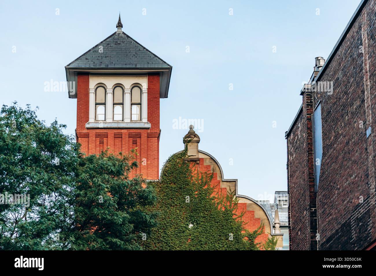 Historic red brick fire station tower and ivy wall of Centre d’histoire ...