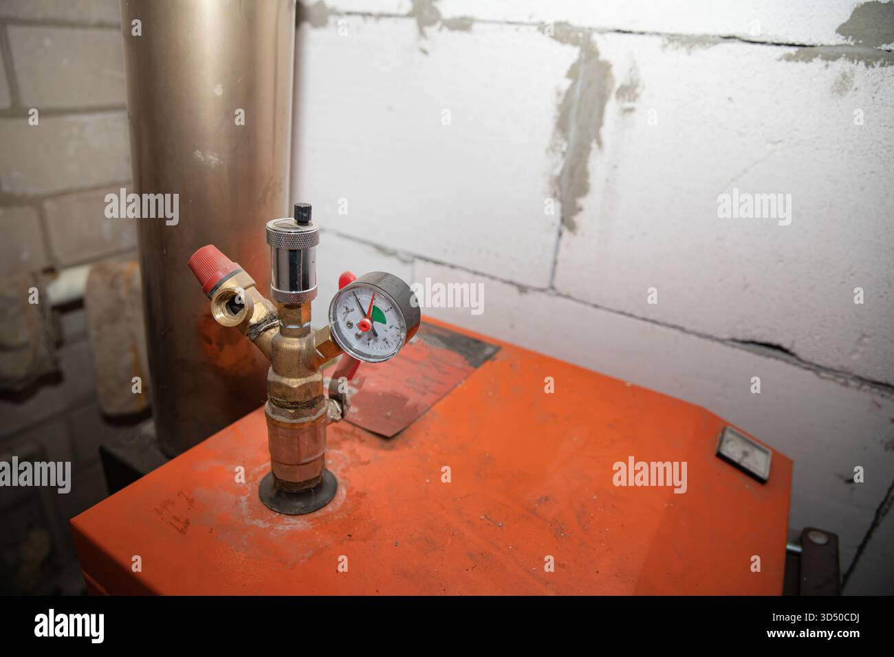 Heating boiler with pressure gauge and safety valve in utility room ...