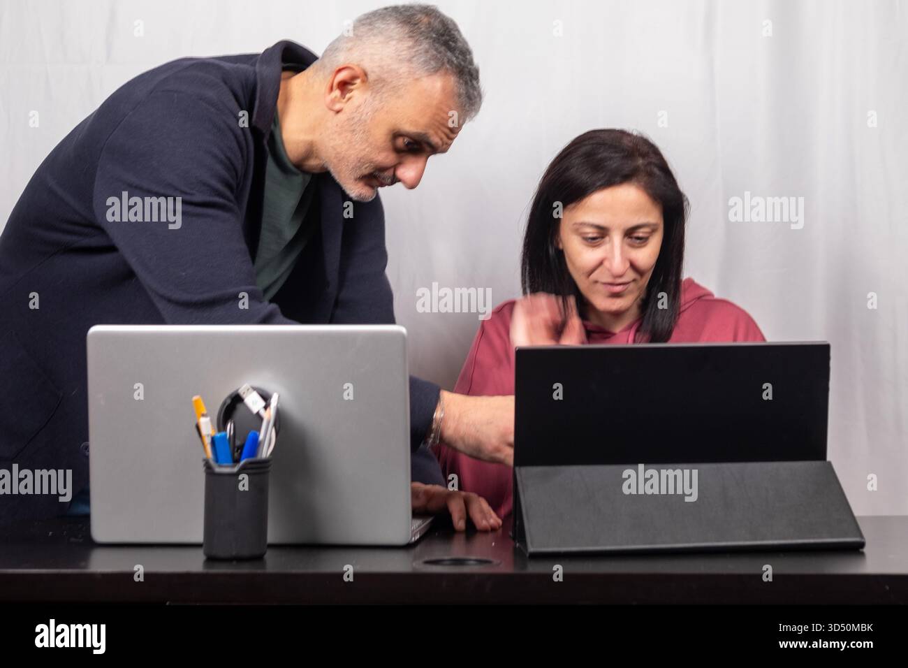 A man and a woman work together in front of the PC. The two colleagues ...