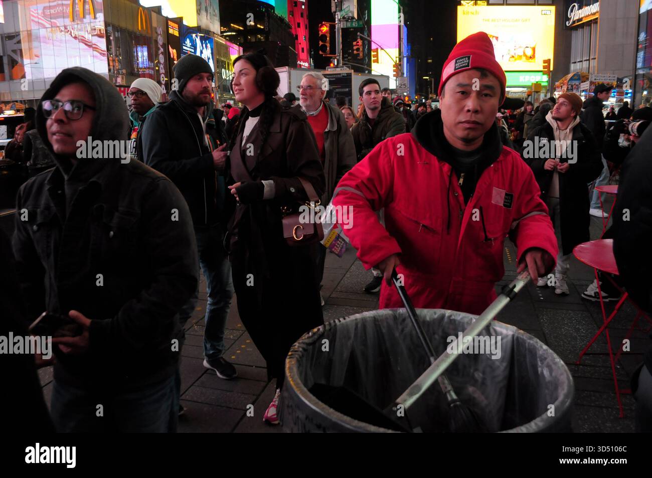 A person pushes a garbage pail in Times Square, Manhattan, New York ...