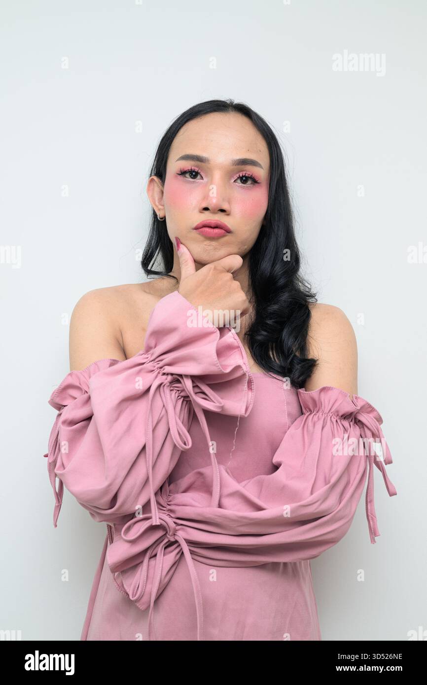 Studio portrait of a young Thai transgender individual with makeup and ...