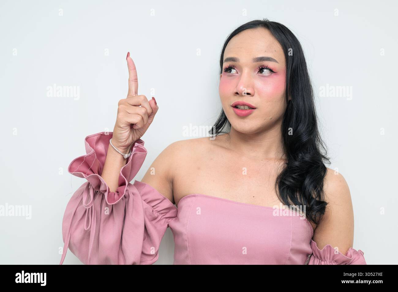 Studio portrait of a young Thai transgender individual with makeup and ...