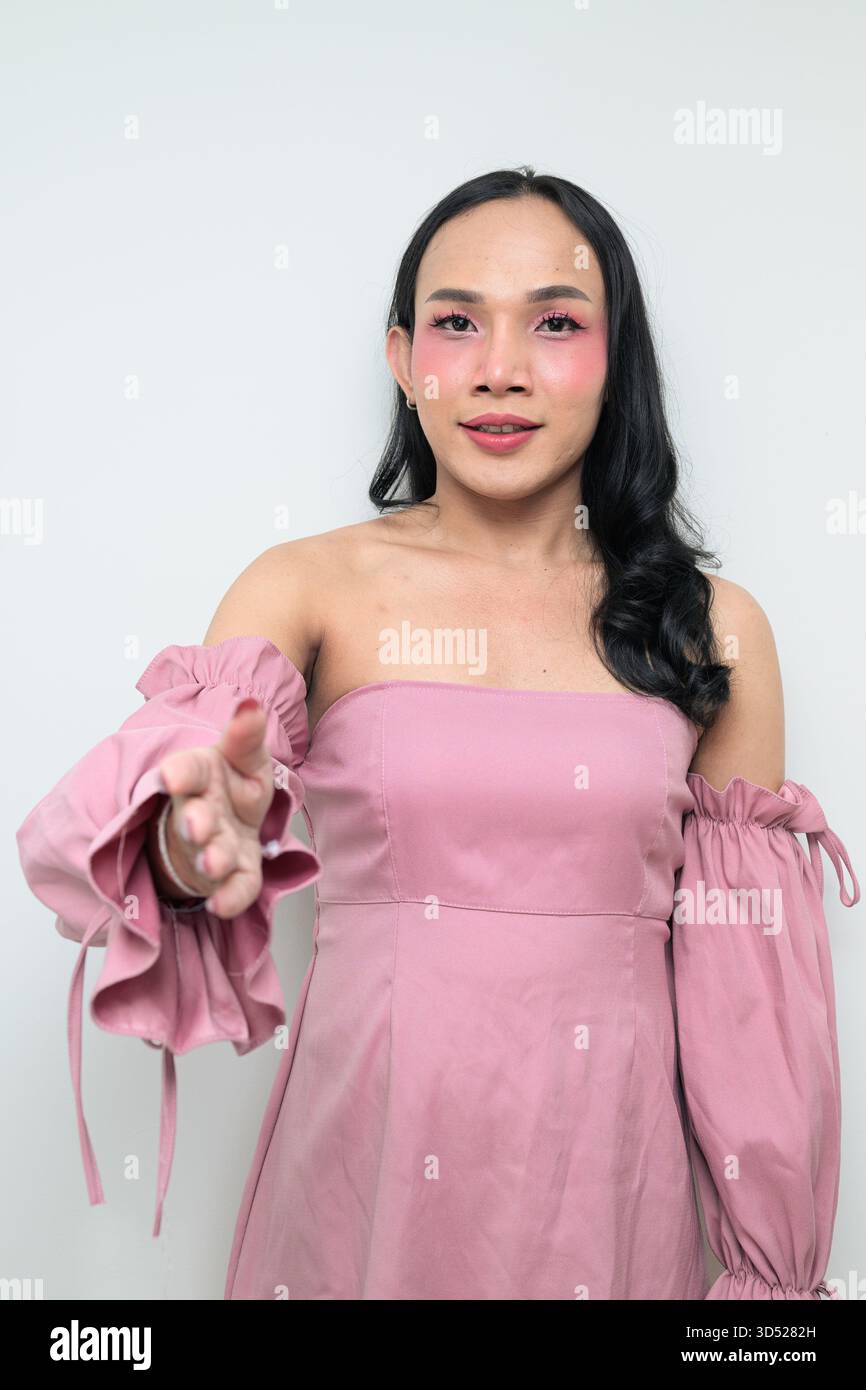 Studio portrait of a young Thai transgender individual with makeup and ...