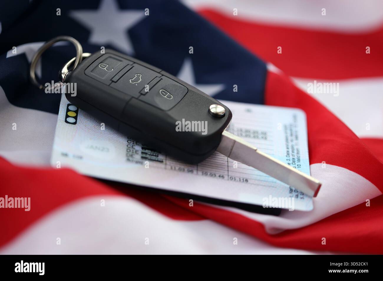 Ignition keys with remote control buttons and driver license card on ...