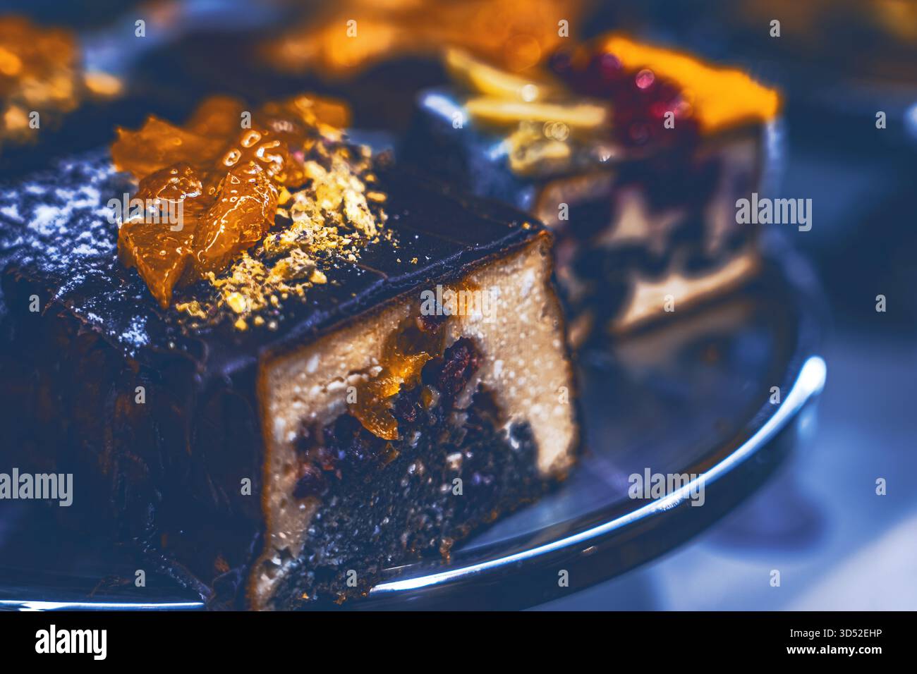 Fresh chocolate cake with golden cream on top on display at a large ...
