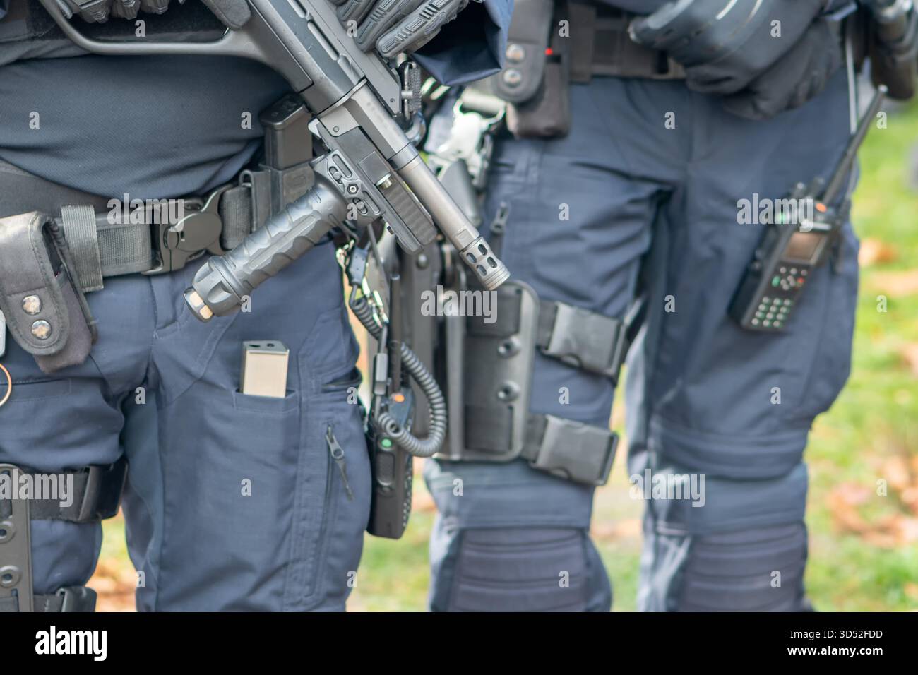 Police officers are standing on the street with guns, a walkie-talkie ...