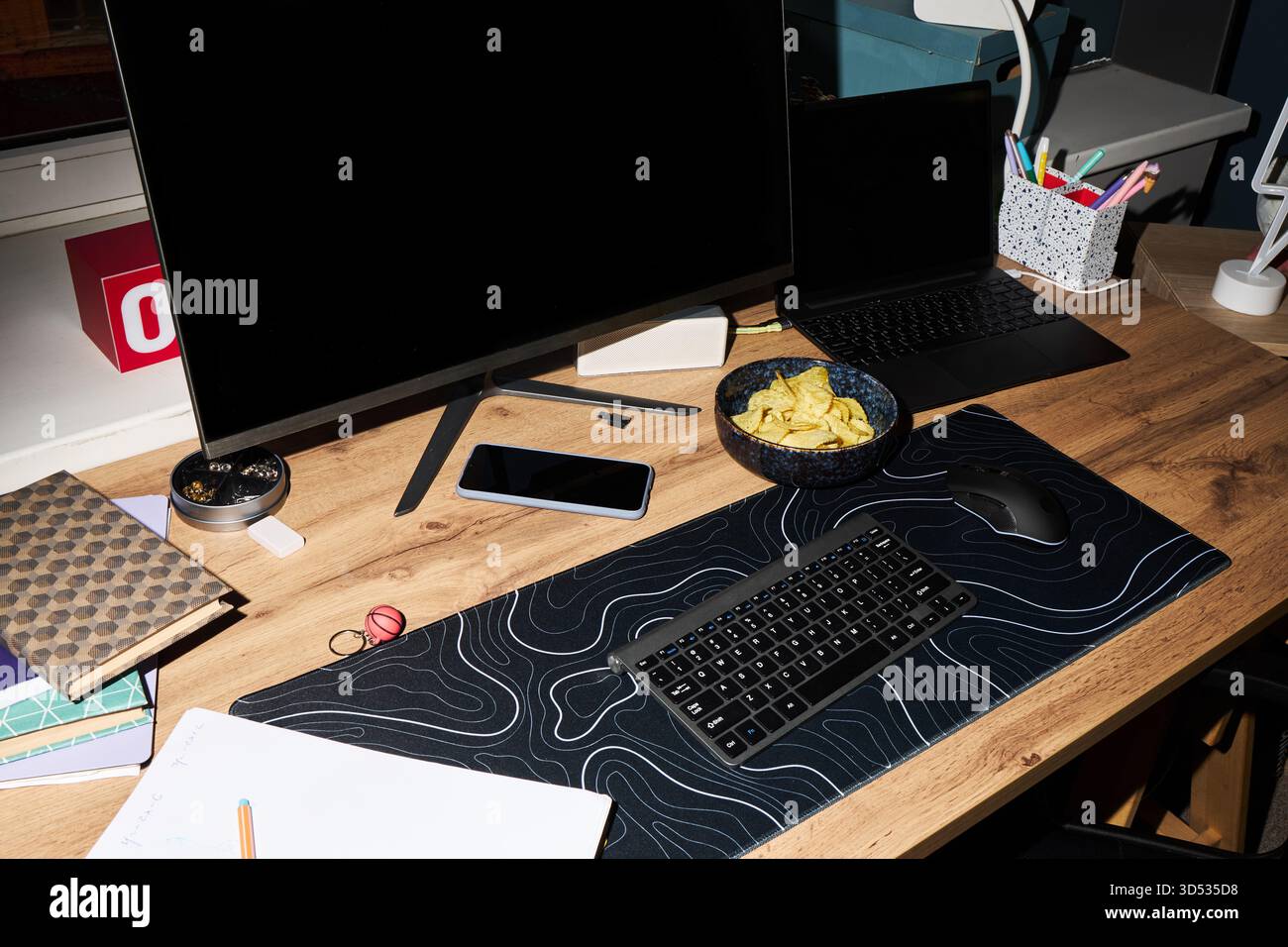 Modern workspace featuring wireless keyboard, computer monitor, laptop ...