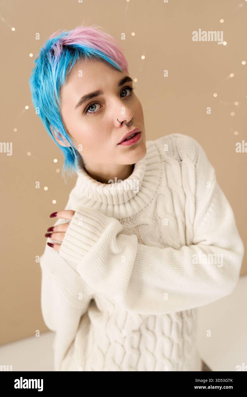 A beautiful young woman with vibrant hair poses warmly in a cozy ...