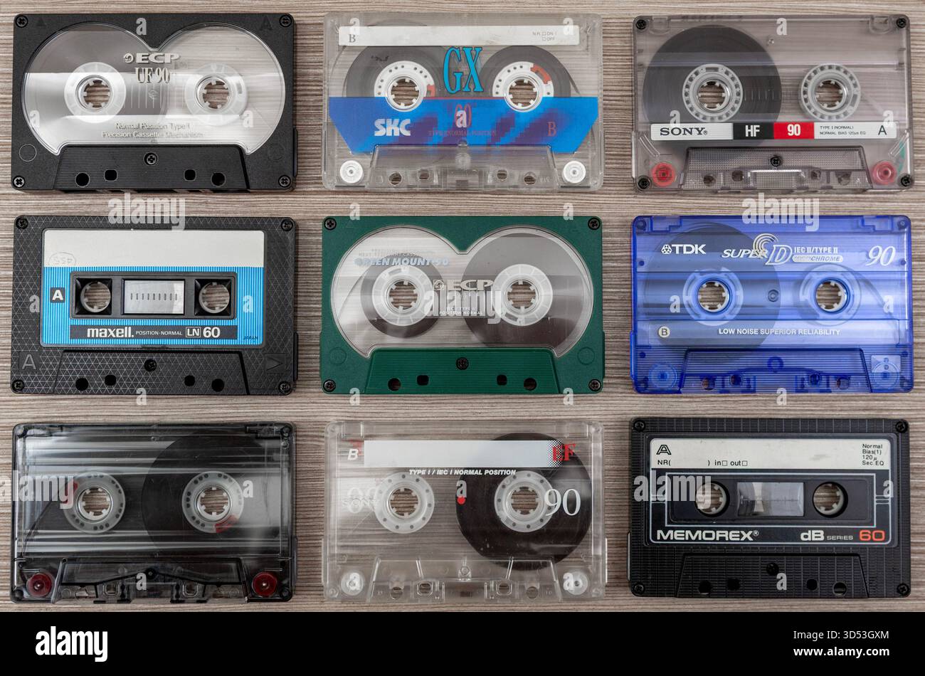 Various vintage audio cassettes are arranged on a plain background ...