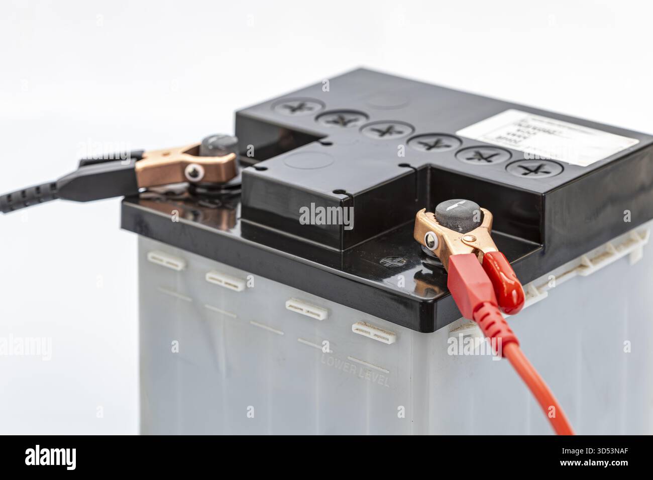 A car battery with jumper cables connected, demonstrating the proper ...