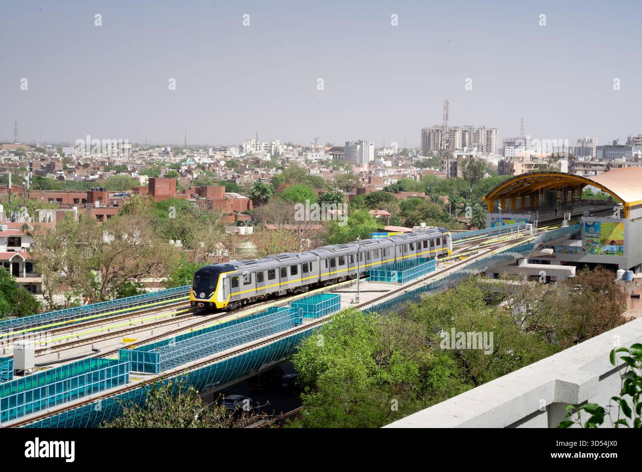 elevated metro station with train parked and passengers getting on ...