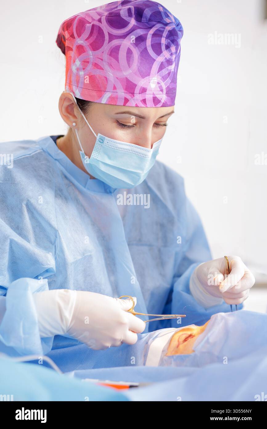 Surgeon closes upper eyelid incision during blepharoplasty under ...