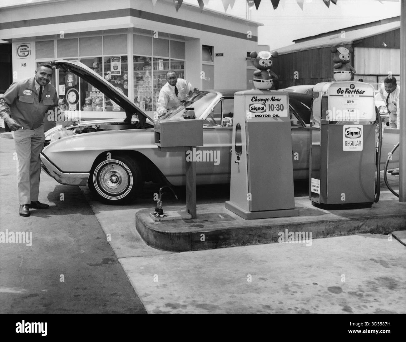 Two men servicing a vehicle at a Signal service station in the 1960s ...