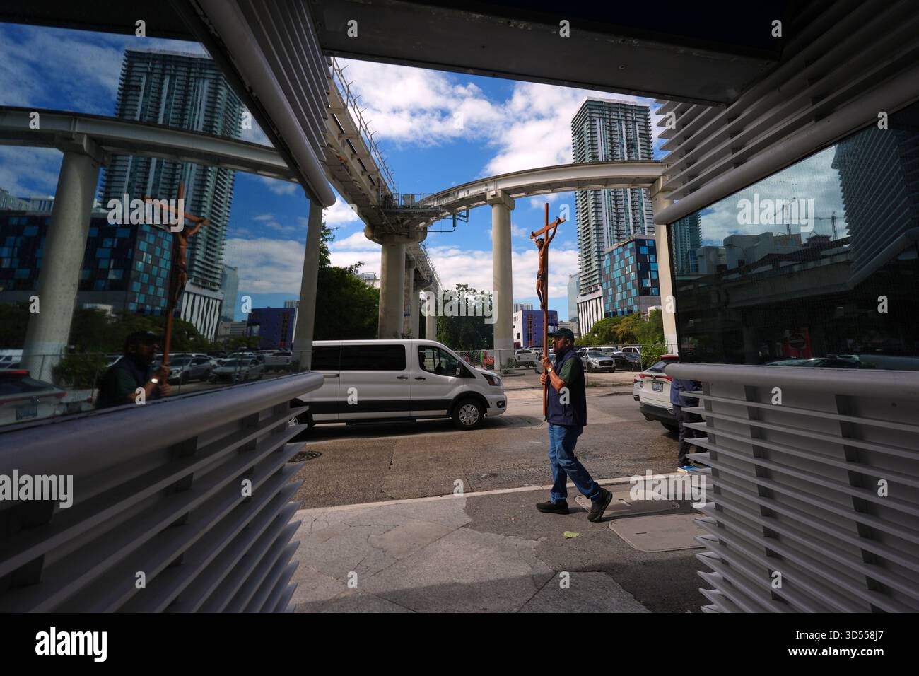 Ramon Ventura carries a wooden Jesus on the Cross figure as people walk ...
