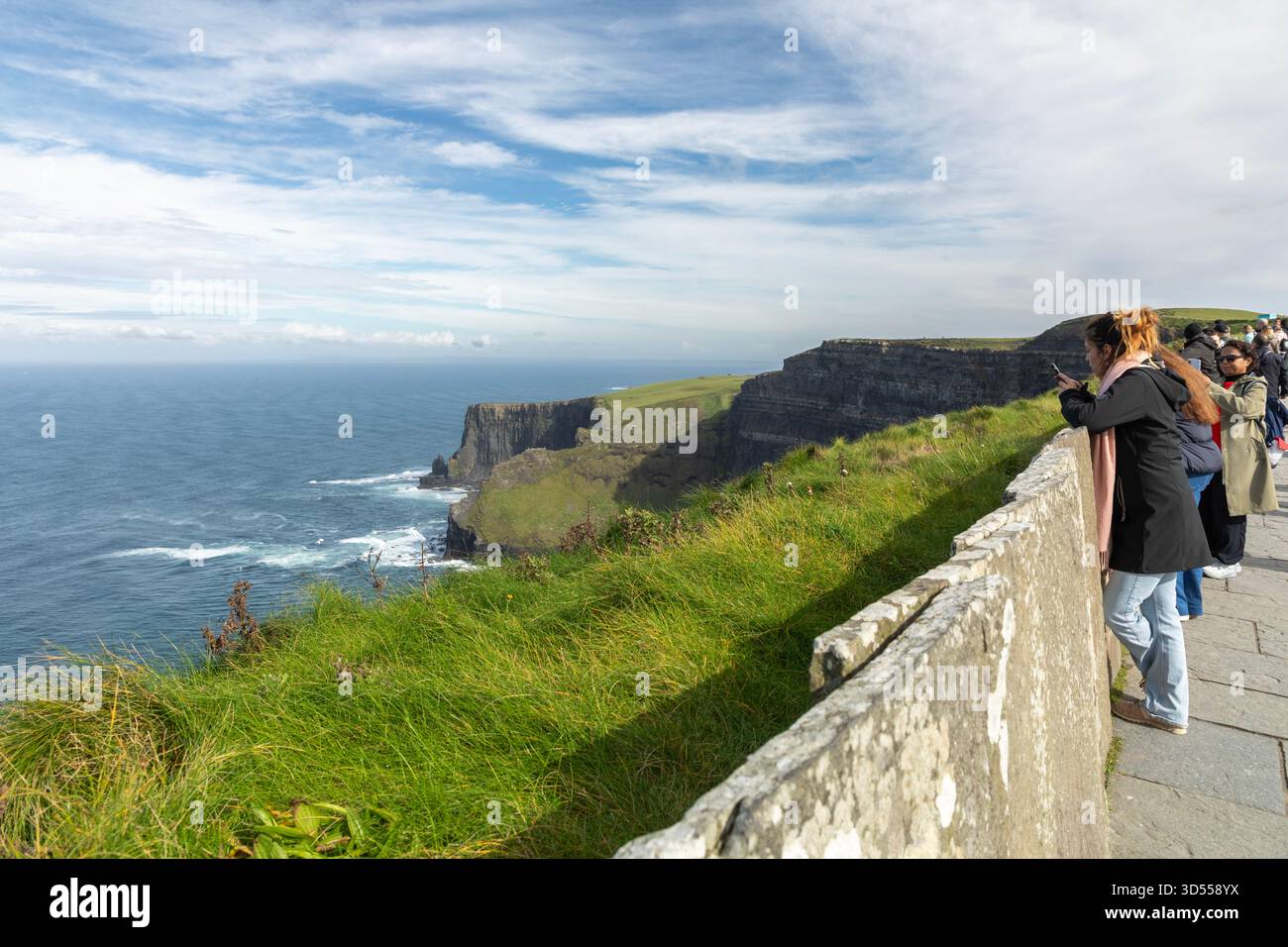 Visitors admire the view at the Cliffs of Moher on the southwestern ...