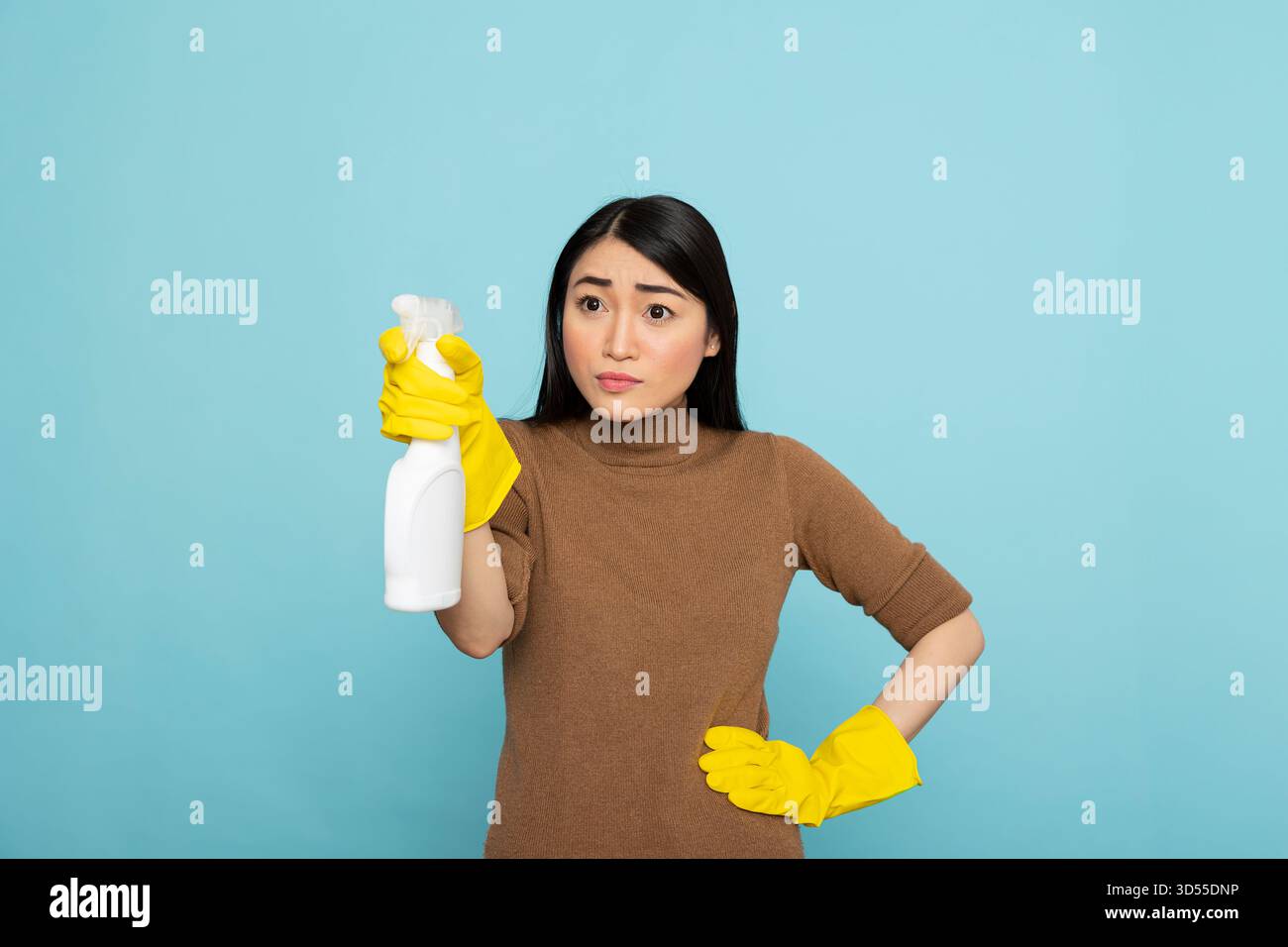Female janitor standing with curious expression and hand on waist ...