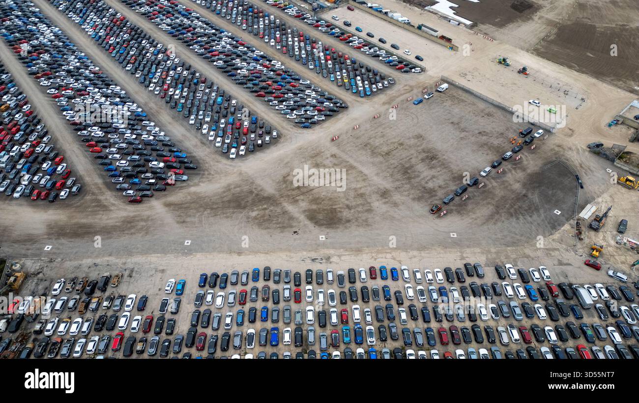 Aerial view of a massive car storage lot filled with rows of vehicles ...