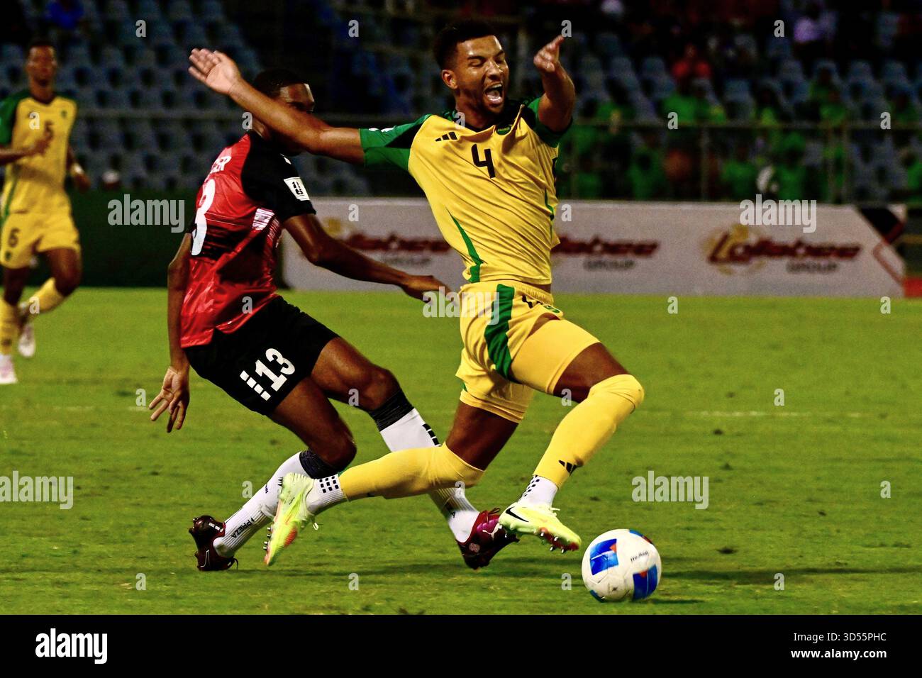 Trinidad and Tobago's Tyrese Spicer, left, tackles Jamaica's Mason ...
