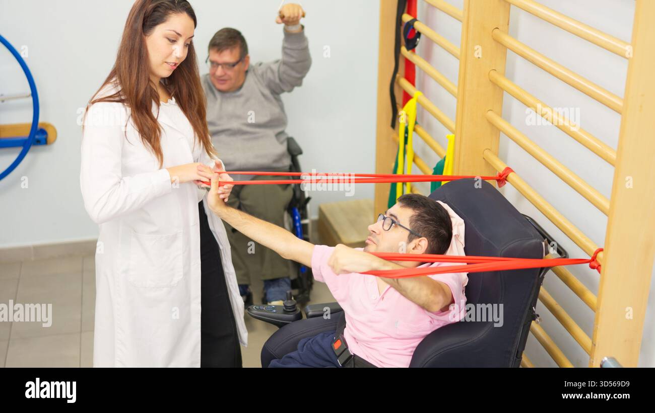 Therapist assisting patient with physical disability doing resistance ...