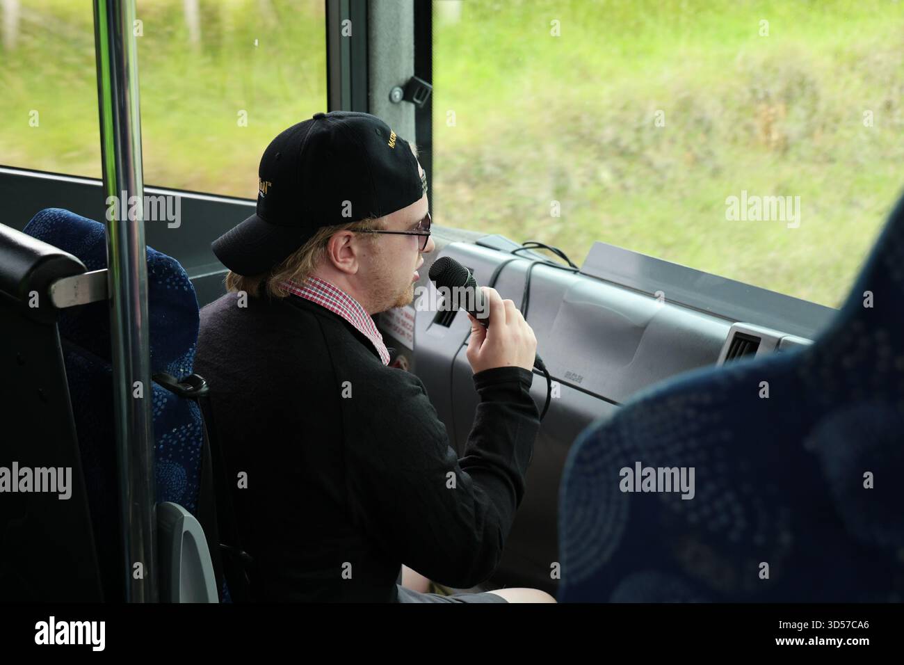 Bus Tour Guide Using Handheld Microphone Stock Photo - Alamy