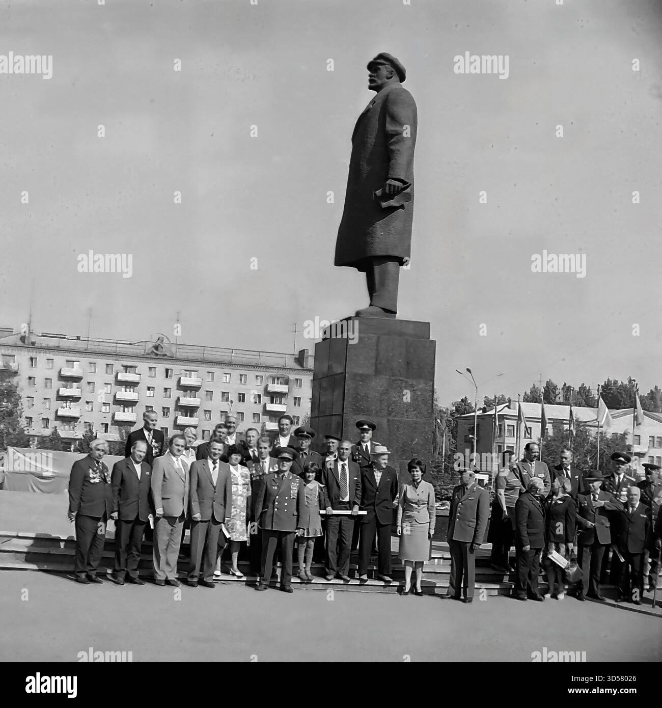 This archival B&W photo from 1985 shows a large, formal group portrait ...