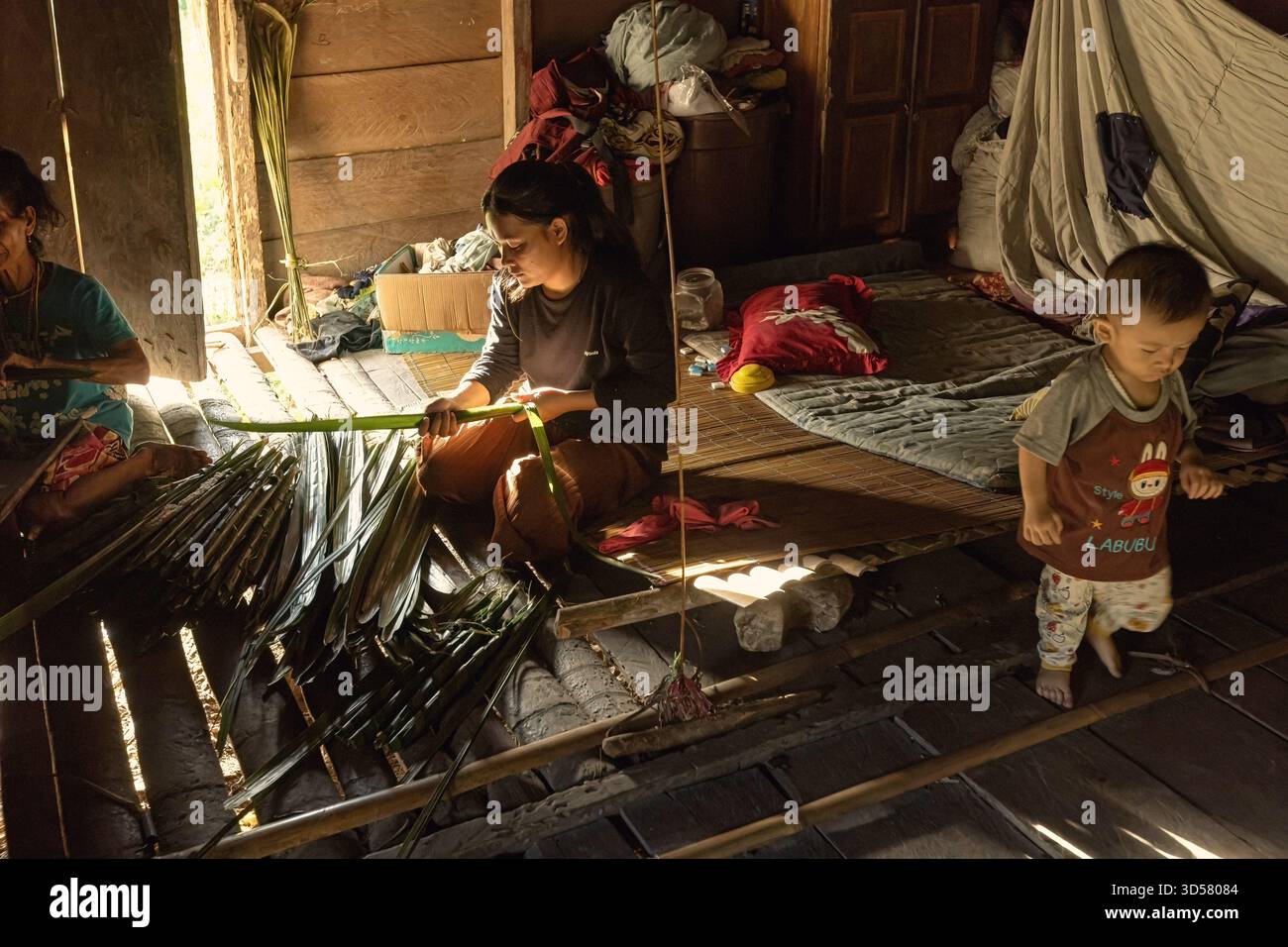 Mentawai woman cooking in the kitchen in the traditional house in the ...