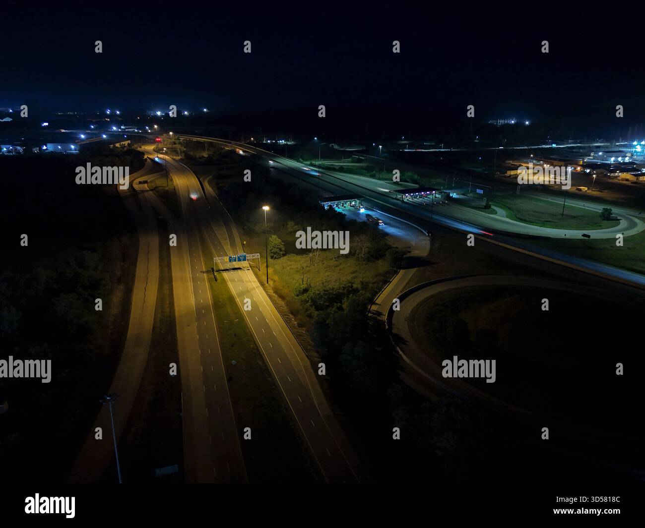 Traffic flows along the brightly lit highway interchange at night Stock ...