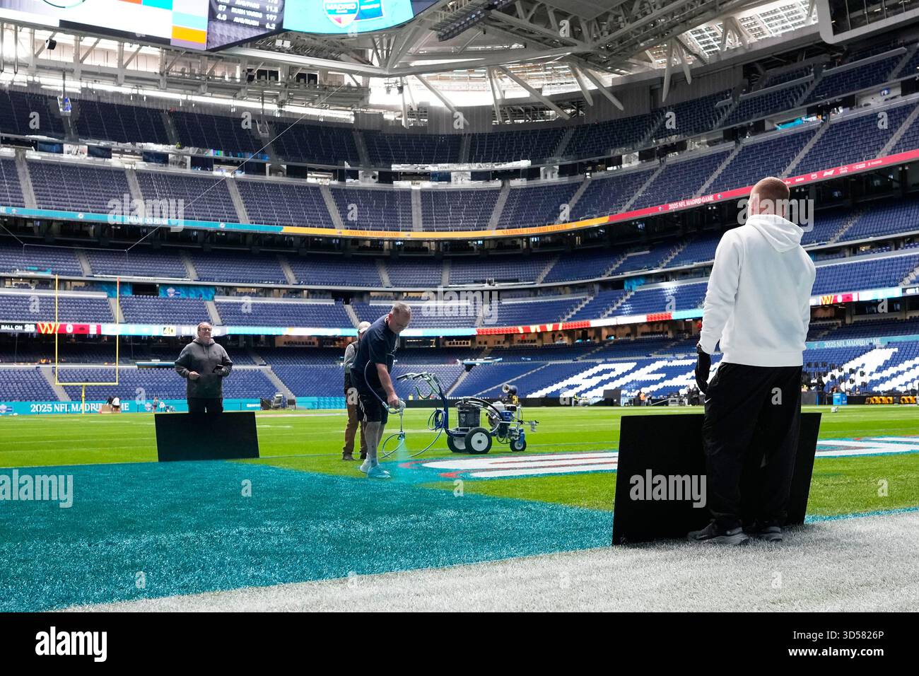 Workers prepare the field at the Santiago Bernabeu stadium ahead of an ...