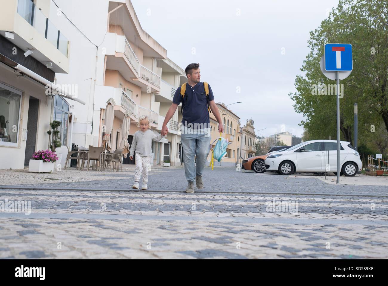 Father and Daughter Crossing the Street While He Holds Her Hand and ...