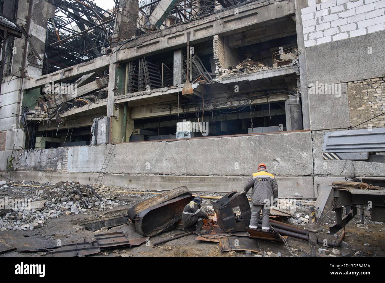 Workers clear the debris at a damaged power plant following Russia's ...