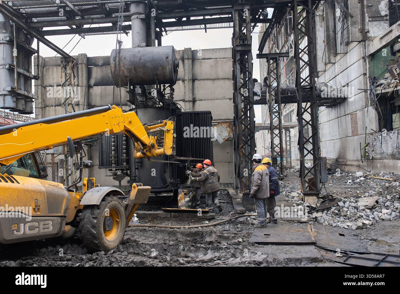Workers clear the debris at a damaged power plant following Russia's ...