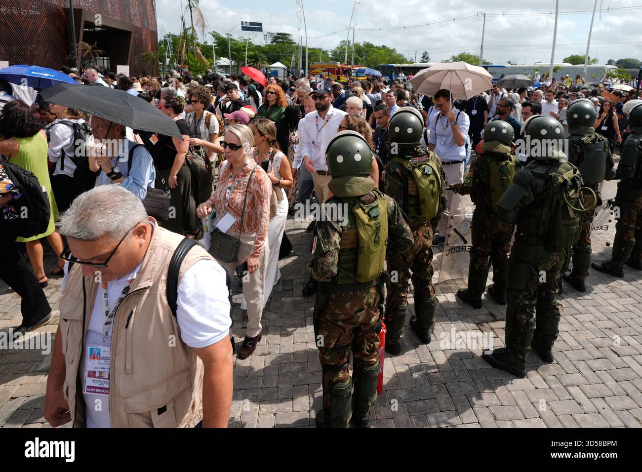 Attendees wait near security personnel to get into the venue for the ...