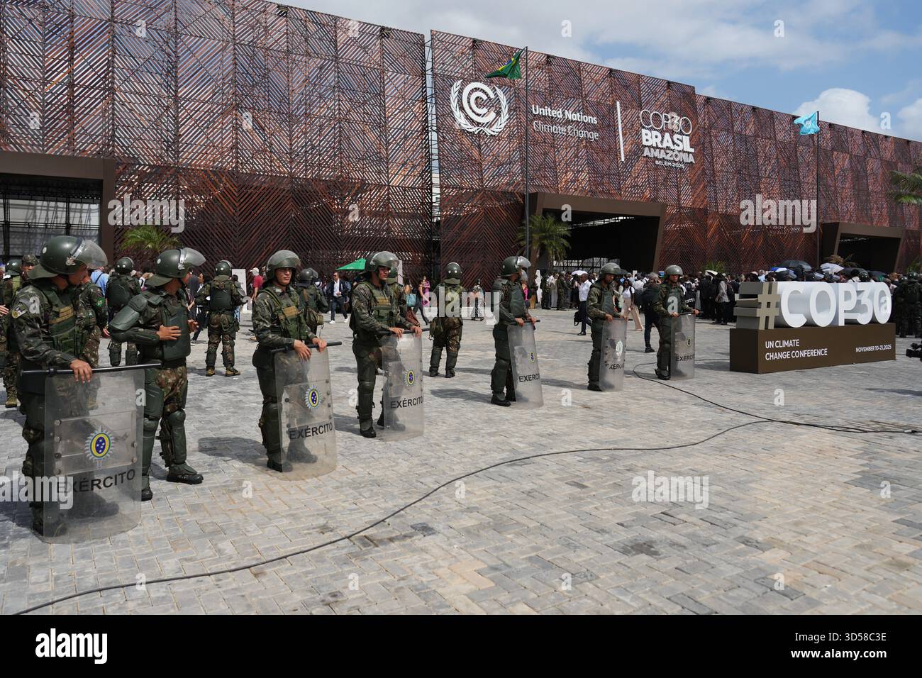 Security personnel stand guard outside an entrance to the COP30 U.N ...