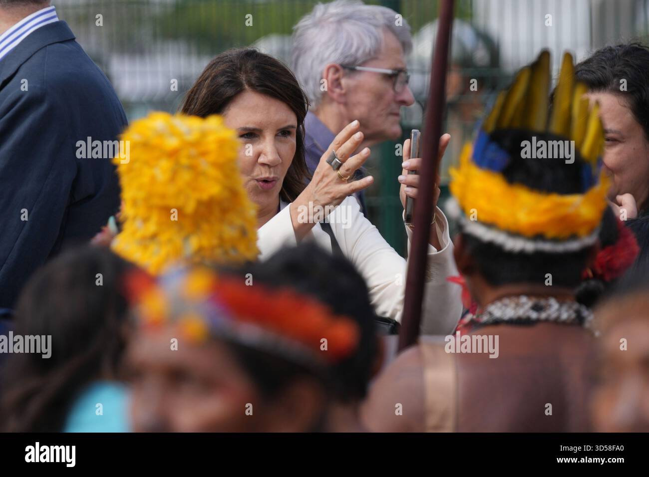 Ana Toni, COP30 CEO, speaks with members of an Indigenous group as they ...