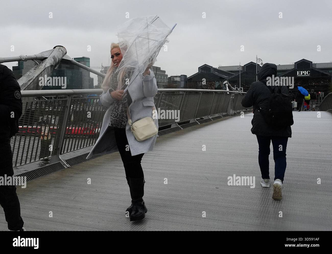 A person holding an umbrella crosses the Sean O'Casey bridge a wet and ...