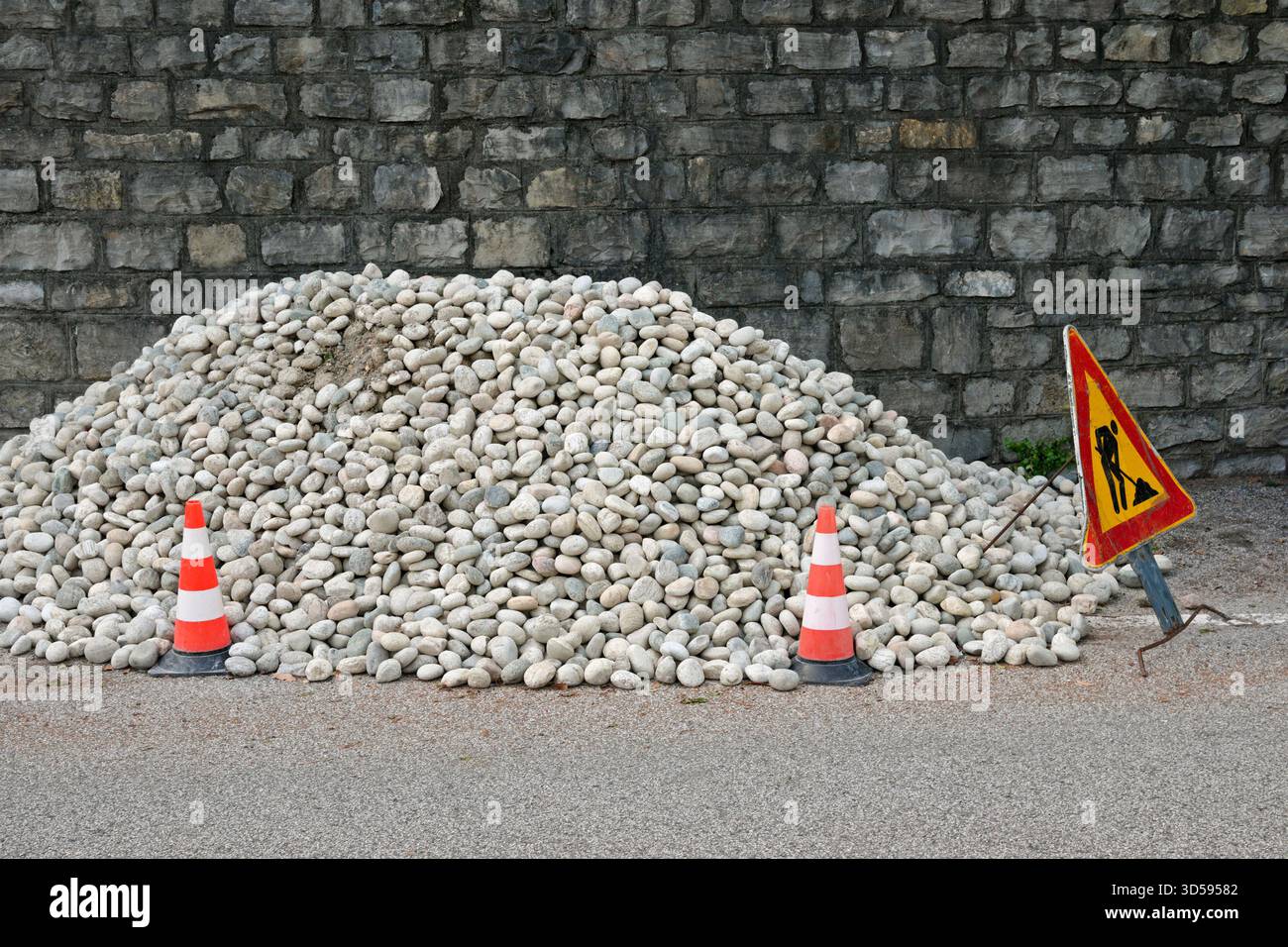 pile of stones with construction cones and road work warning sign Stock ...