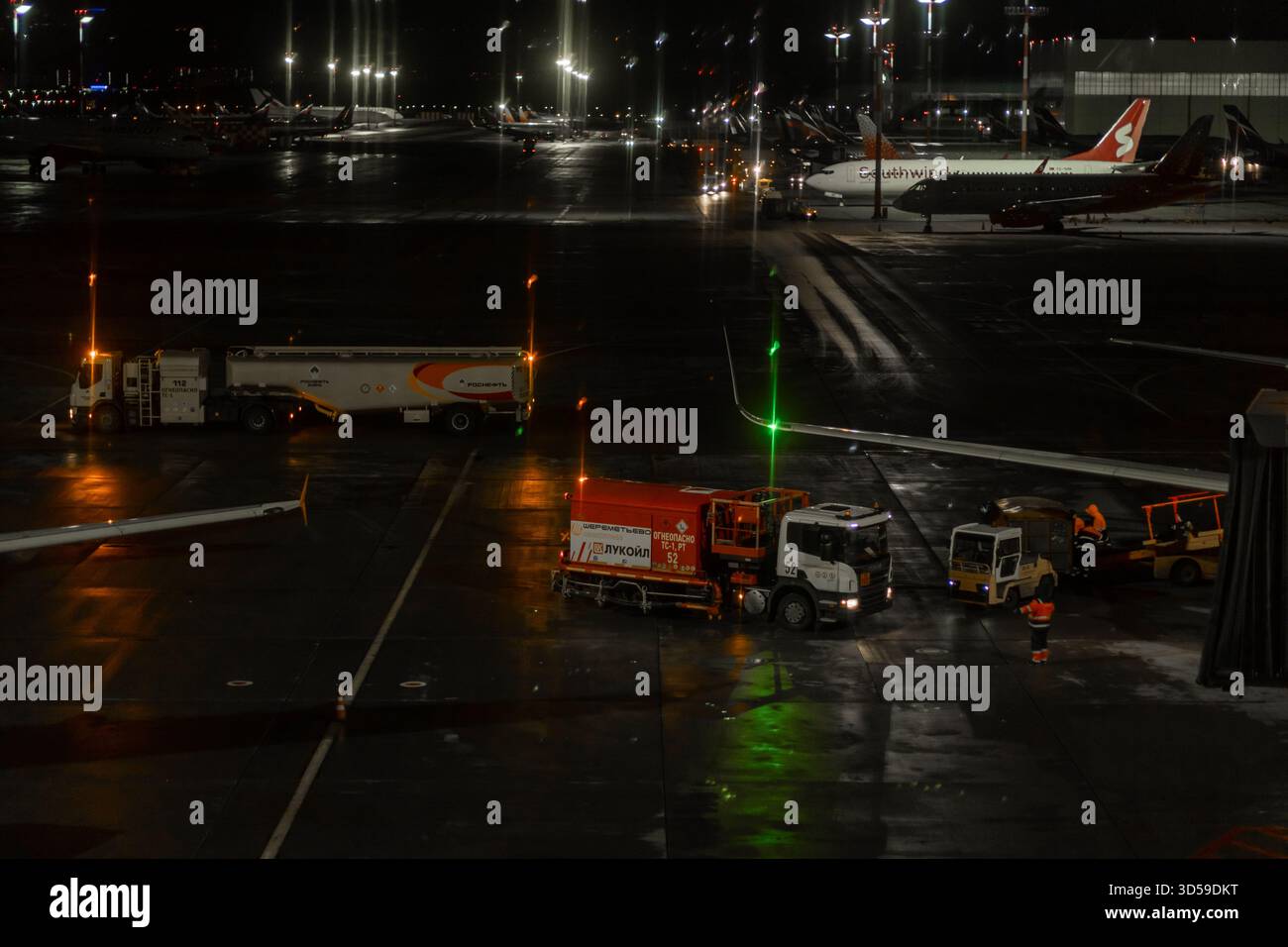 Evening Airport Activity With Planes, Ground Vehicles, and Lights ...