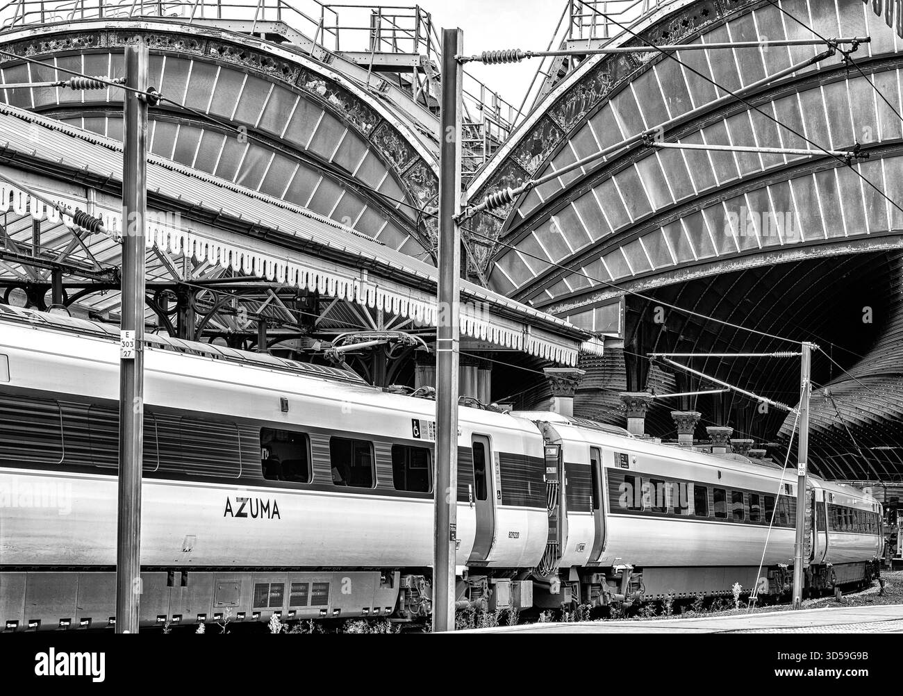 A line of train carriages emerge from an interior and are stationary ...