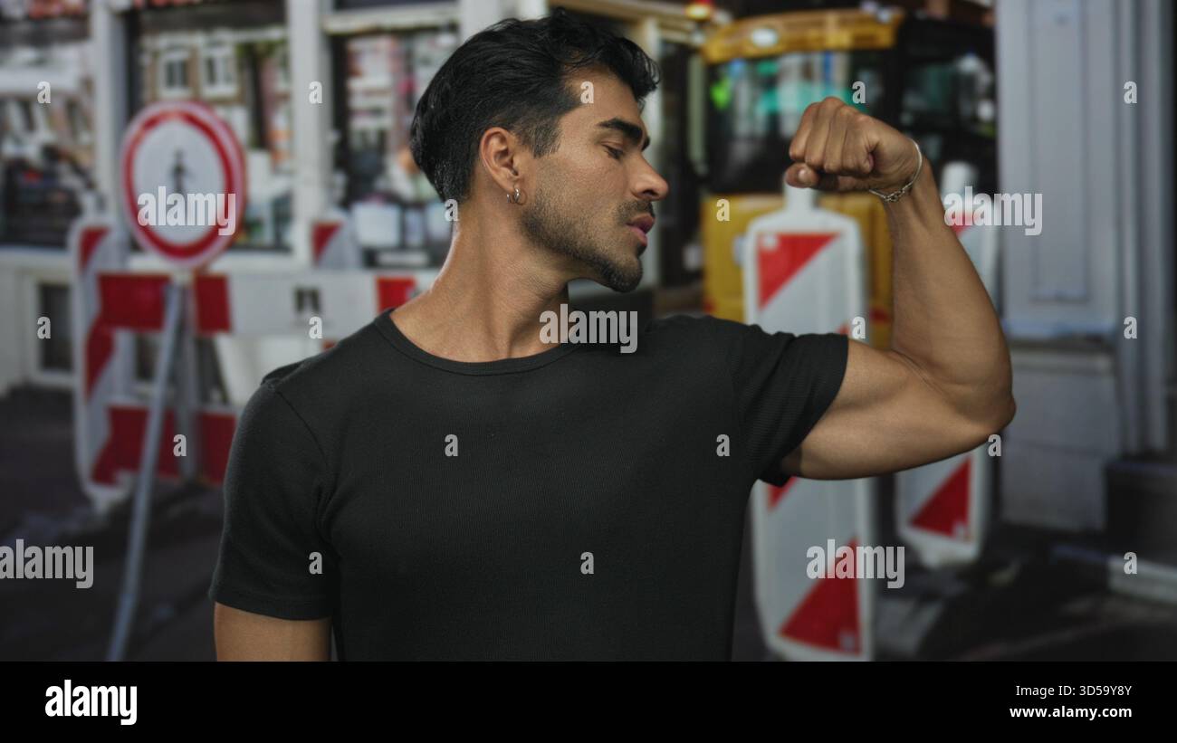 Man flexes bicep on street next to traffic barrier signaling roadwork ...